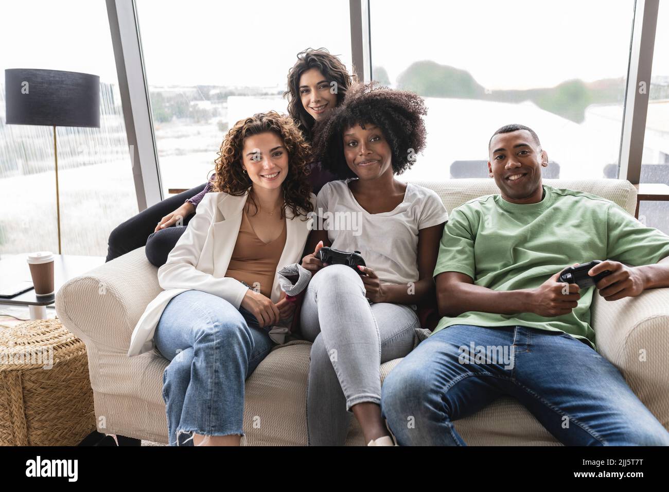 Happy friends sitting on sofa together Stock Photo - Alamy