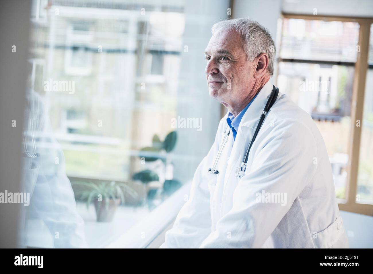 Doctor looking through window hi-res stock photography and images - Alamy