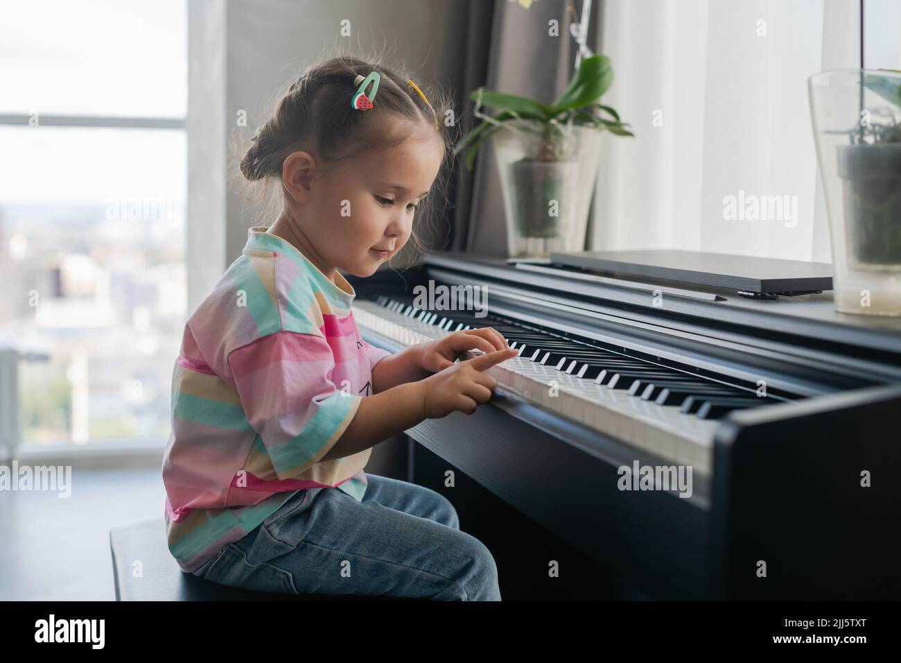 Preschool asian child learning to play music instrument. Education ...