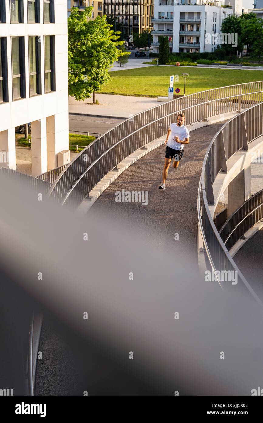 Man jogging on elevated walkway Stock Photo - Alamy