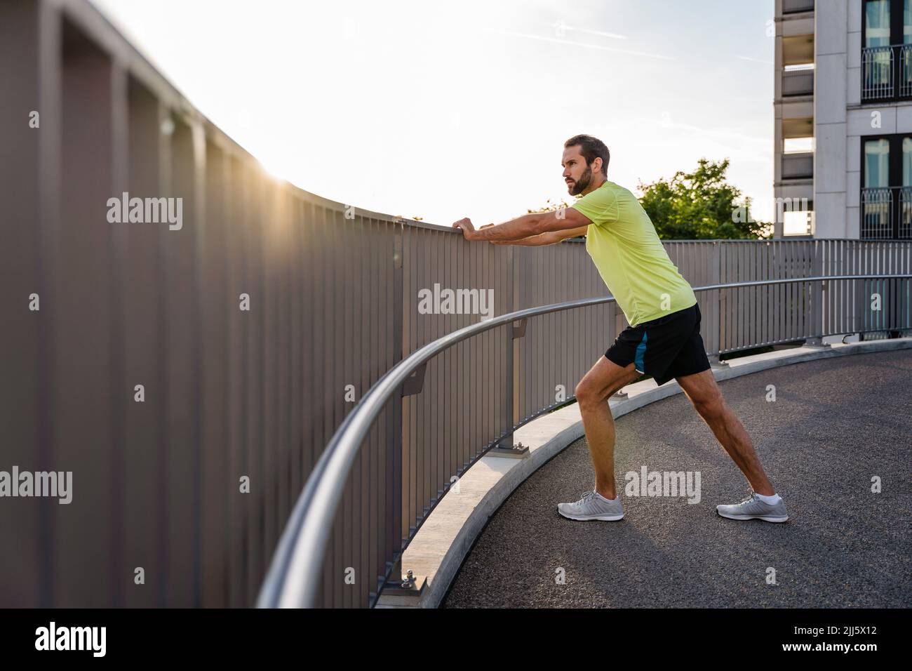 Man leaning on railing of footbridge Stock Photo - Alamy