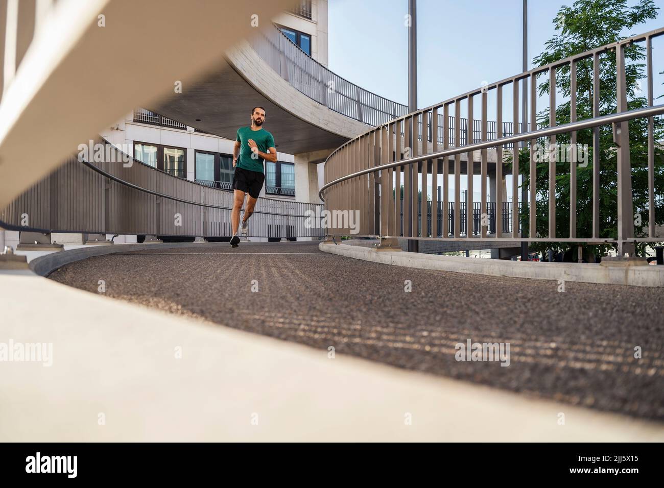 Young man jogging on elevated walkway Stock Photo - Alamy