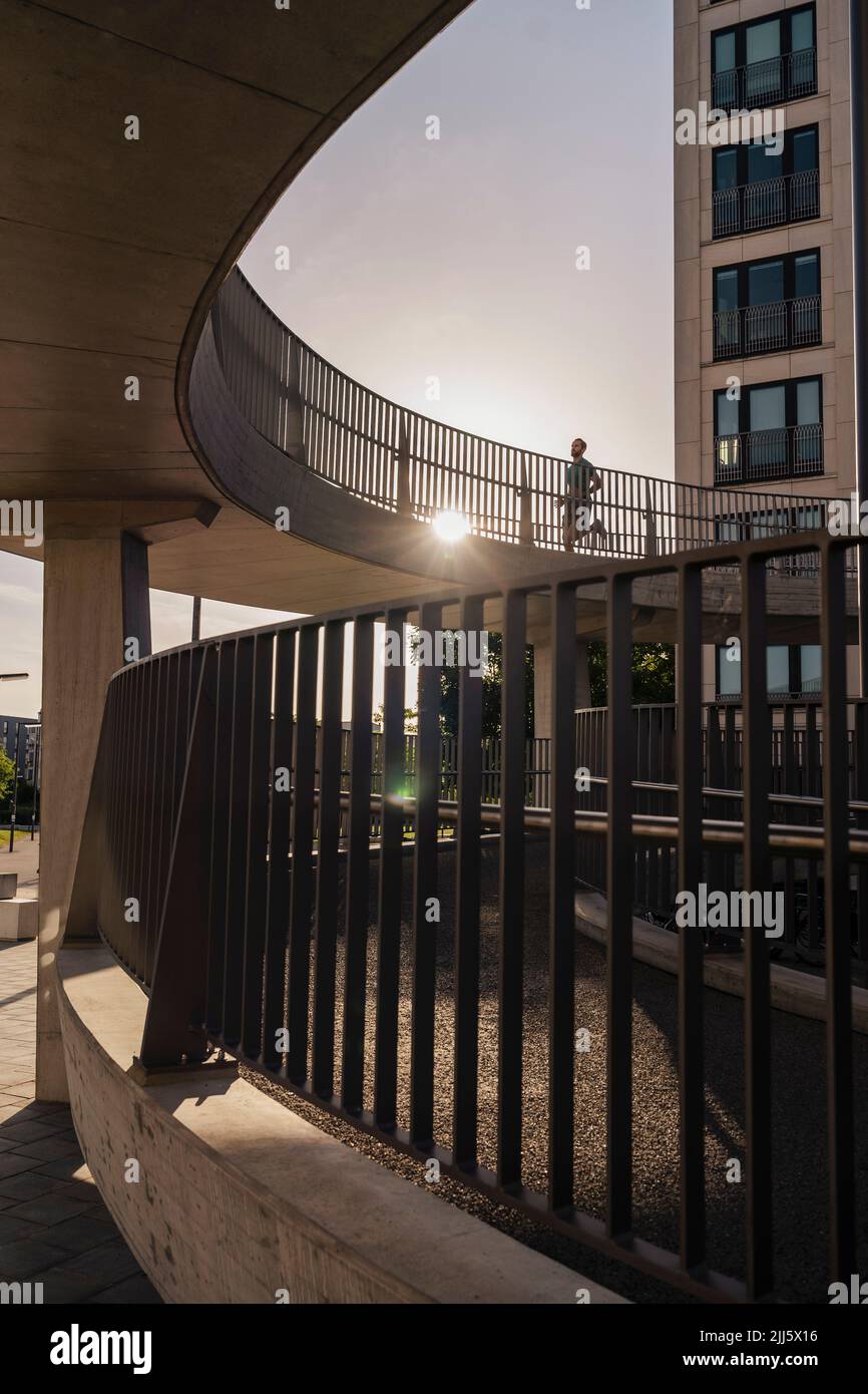 Silhouette man running on elevated walkway Stock Photo - Alamy