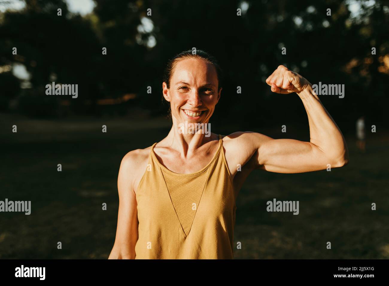 Mid adult woman flexing bicep hi-res stock photography and images - Alamy