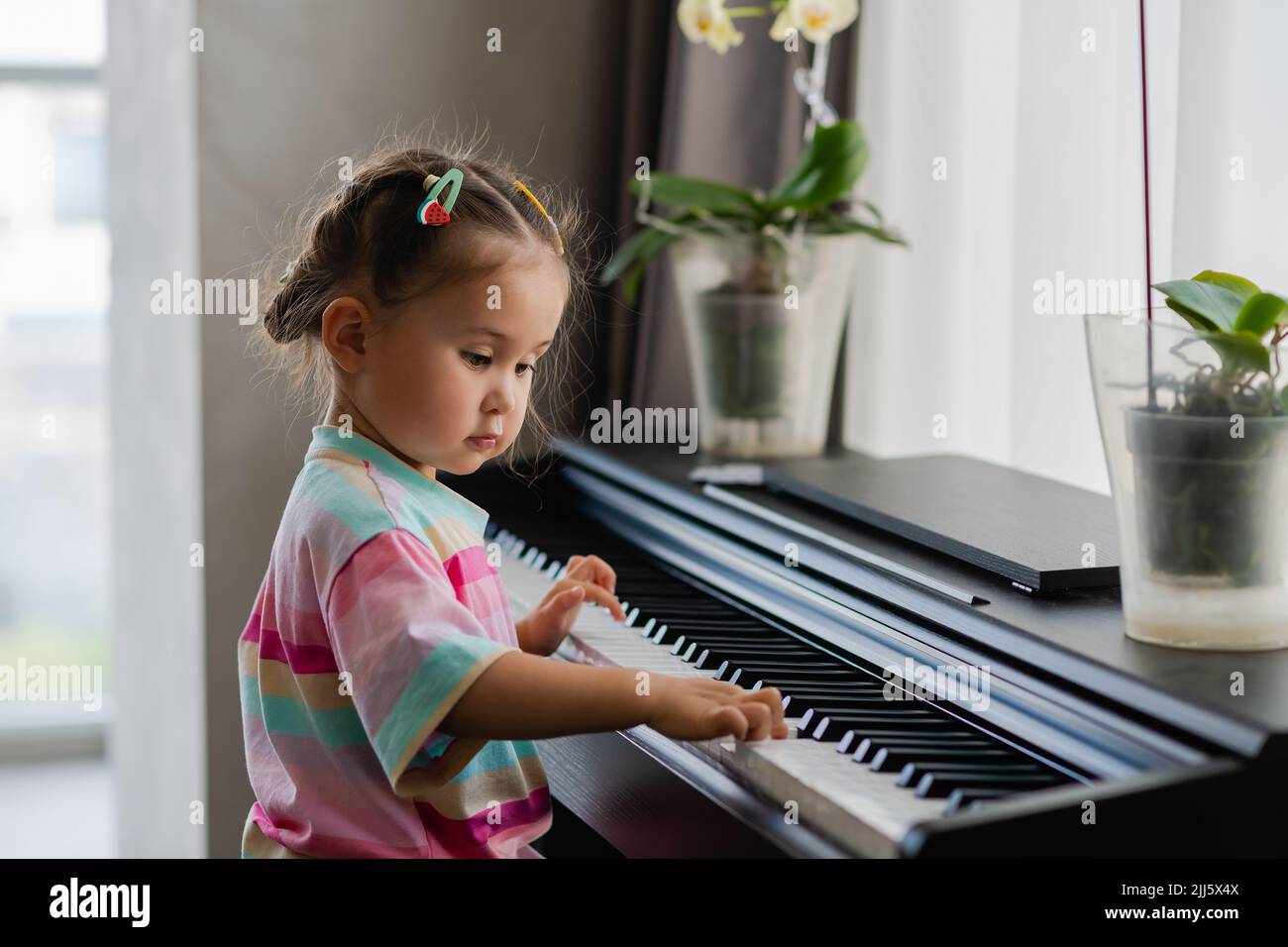 Preschool child learning to play music instrument. Education, skills ...