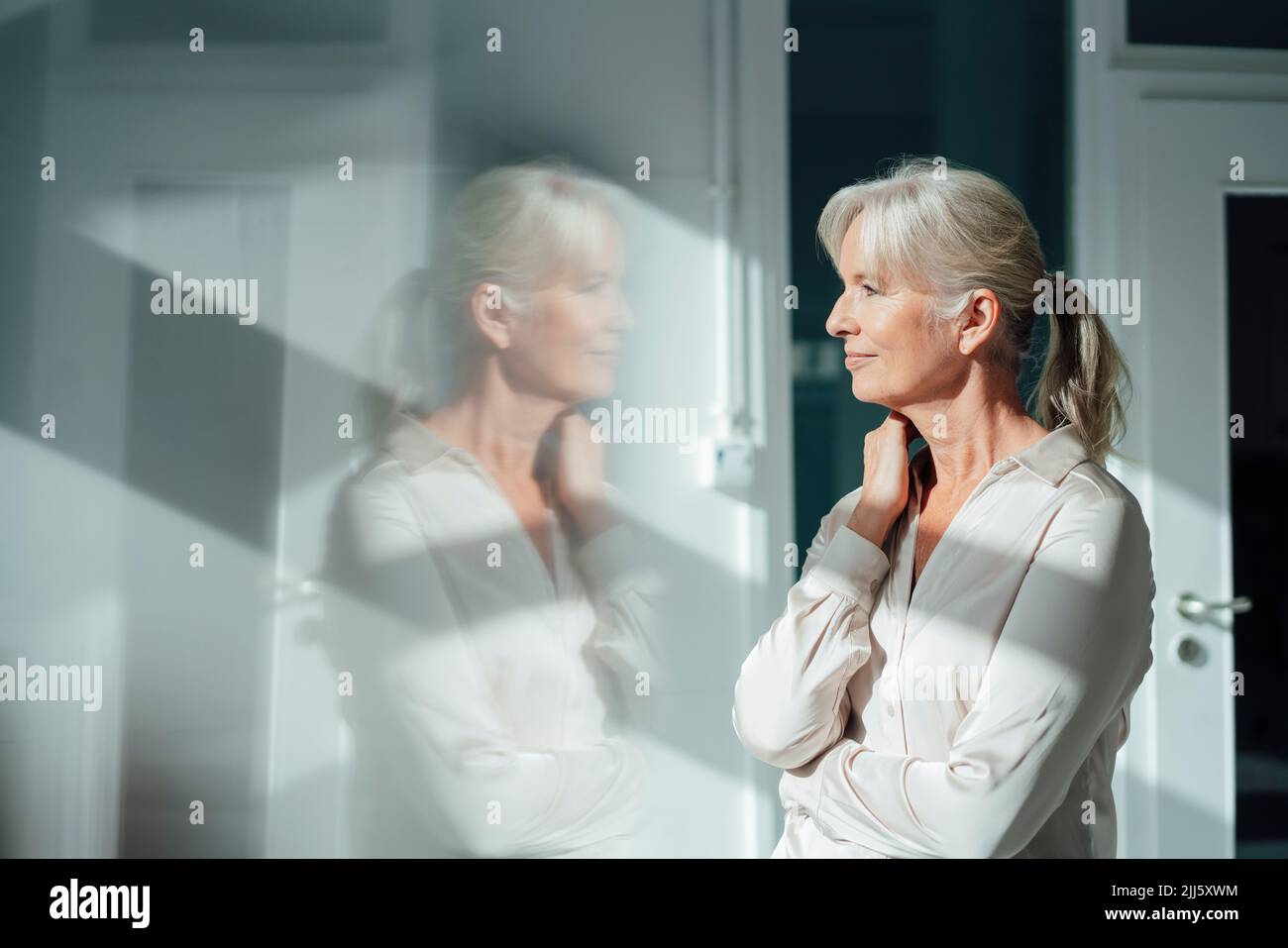 Smiling women looking out from a window hi-res stock photography and ...