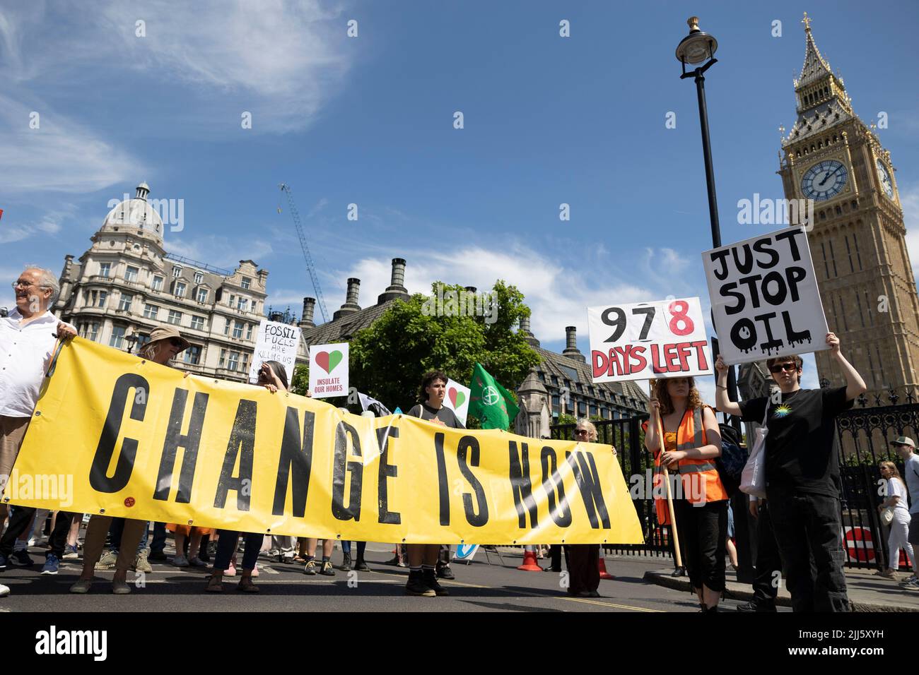 Protesters hold a banner and placards in front of the UK Parliament ...
