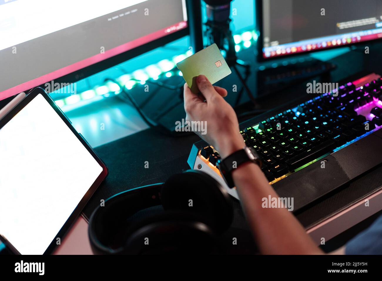 Man holding credit card in front of desktop PC at home Stock Photo - Alamy