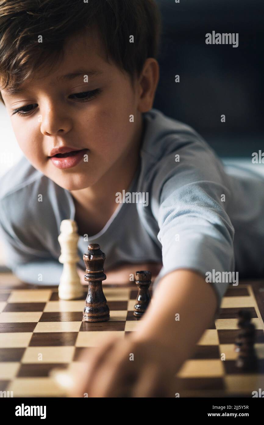 Cute boy playing chess at home Stock Photo - Alamy