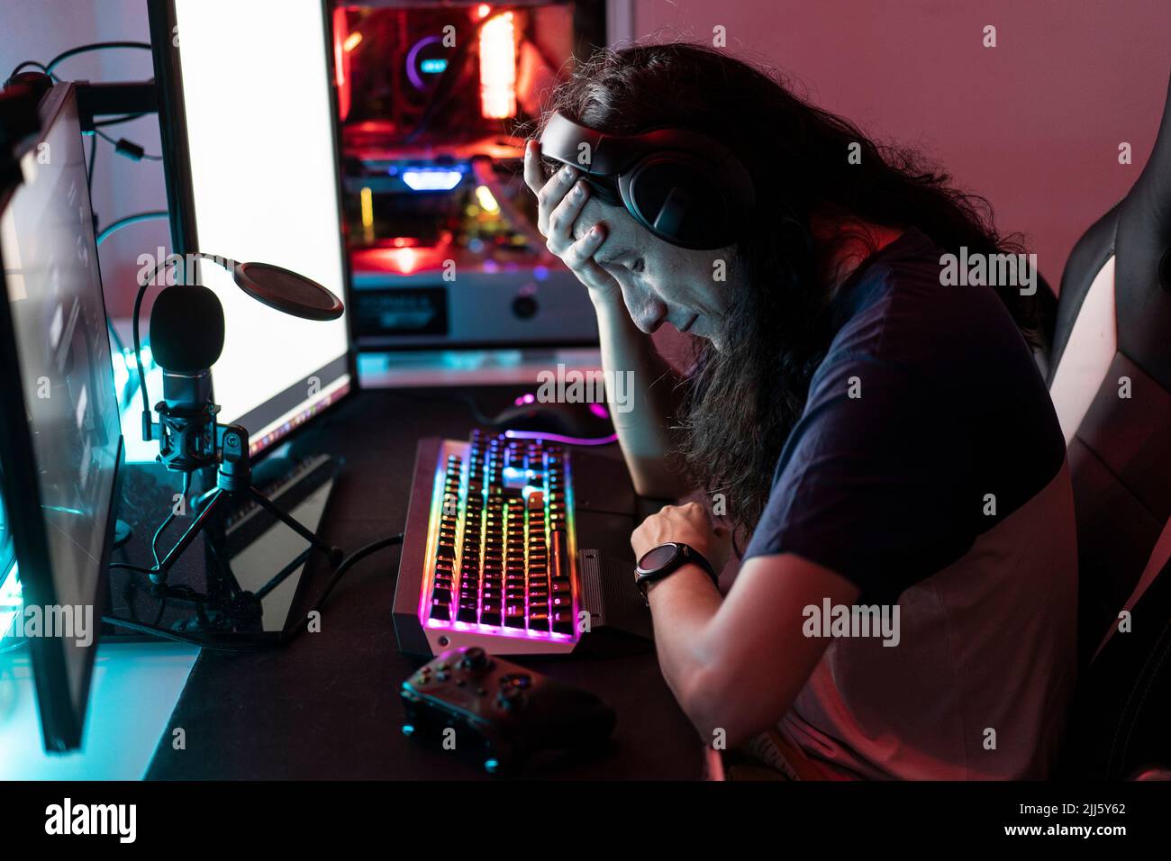 Stressed gamer sitting with head in hand at home Stock Photo - Alamy