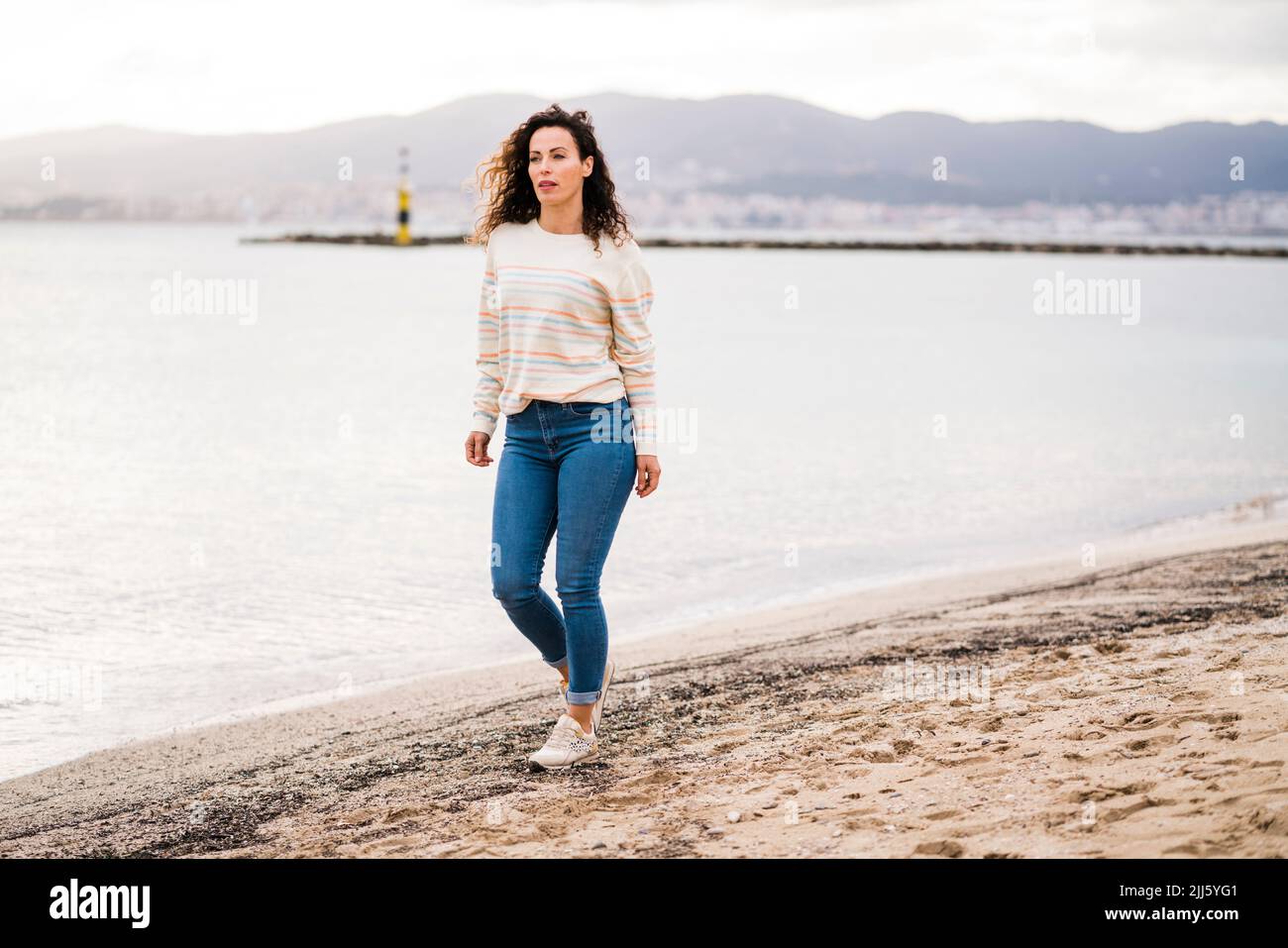 Mature woman walking on beach at weekend Stock Photo - Alamy