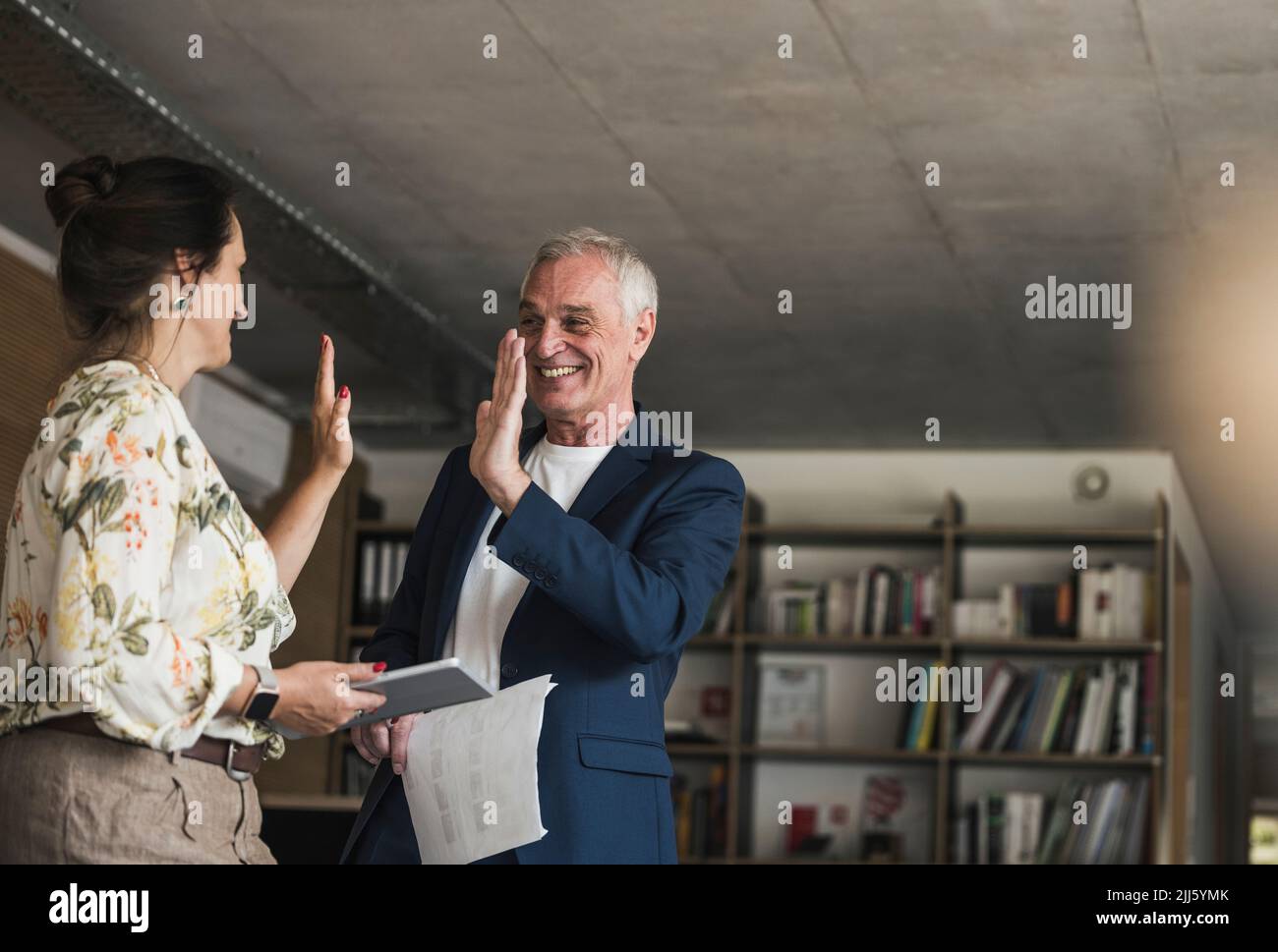 Happy businessman giving high-five to colleague at work place Stock ...