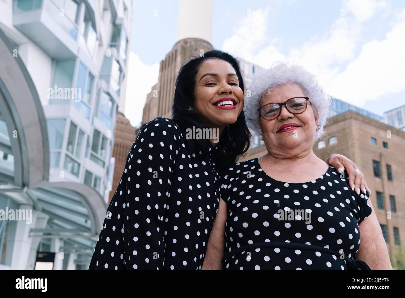 Daughter standing with arm around on mother Stock Photo - Alamy