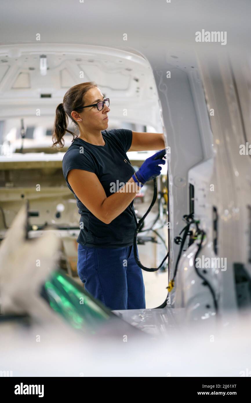 Female worker at a car factory assembly line Stock Photo - Alamy