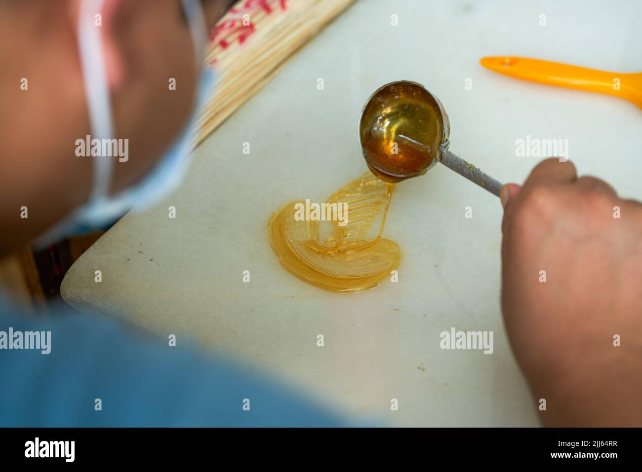 A craftsman is making traditional Chinese snacks, painting sugar ...