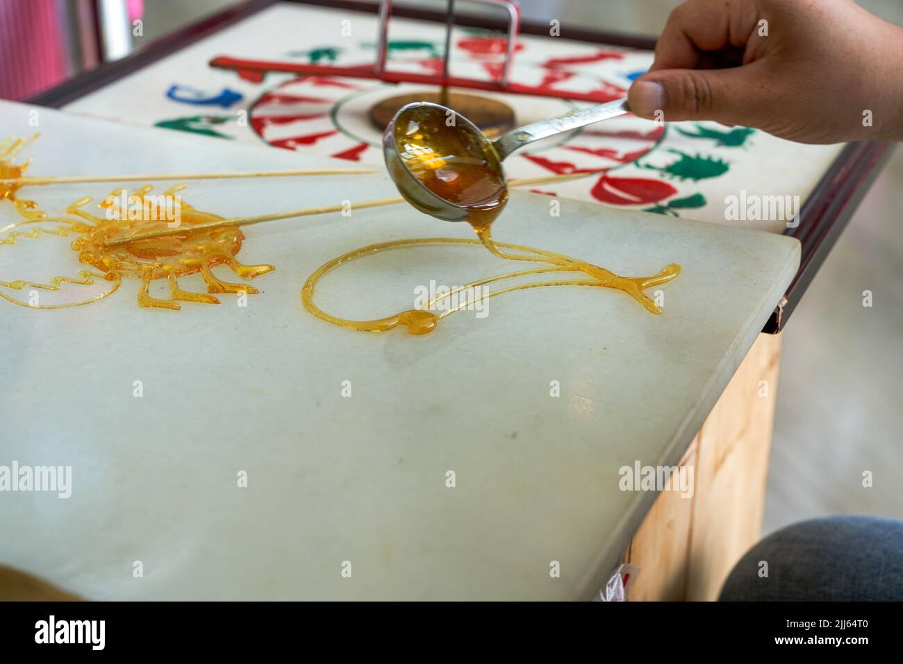 A craftsman is making traditional Chinese snacks, painting sugar ...