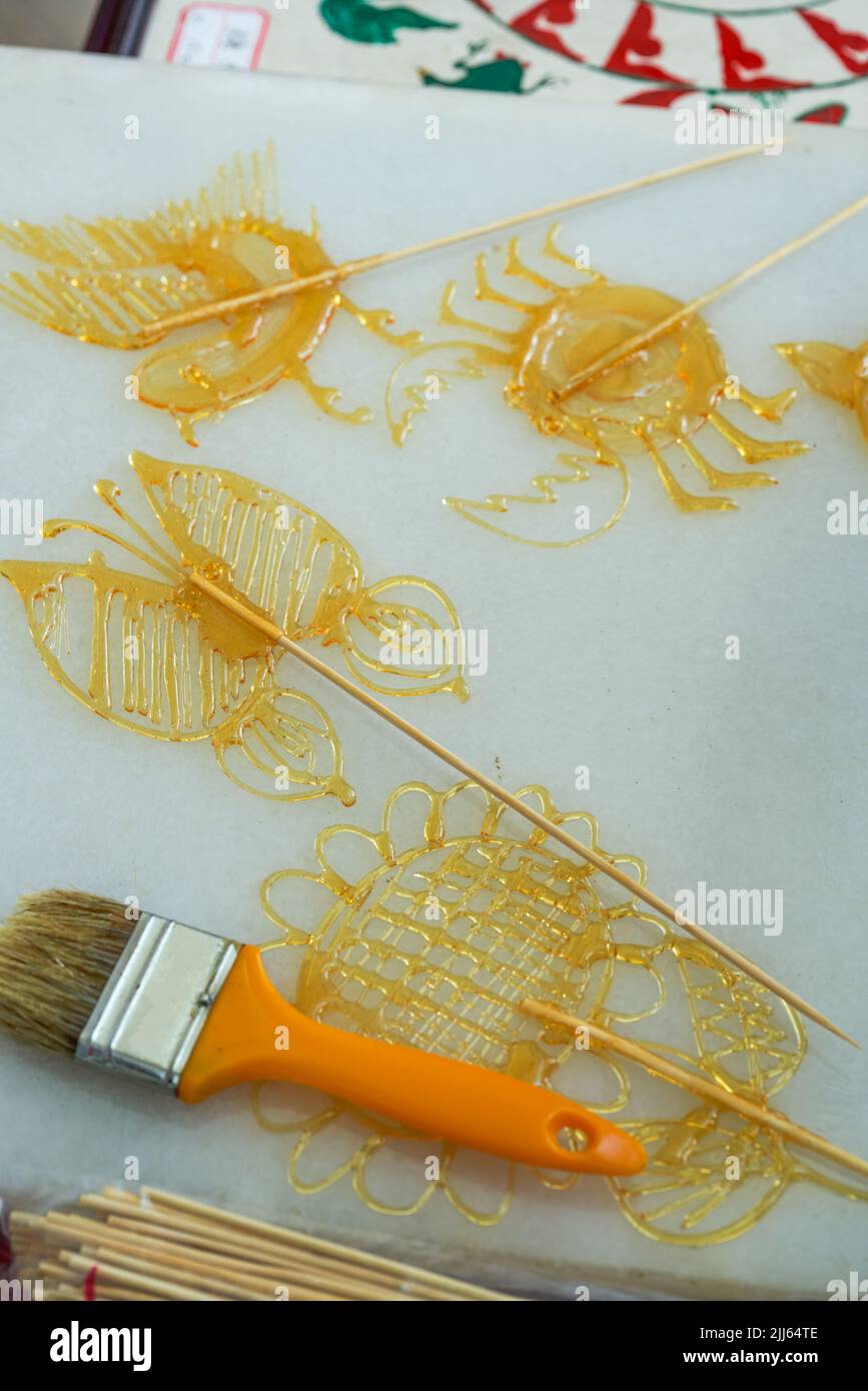 A craftsman is making traditional Chinese snacks, painting sugar ...