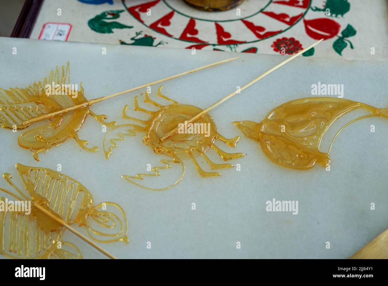 A craftsman is making traditional Chinese snacks, painting sugar ...