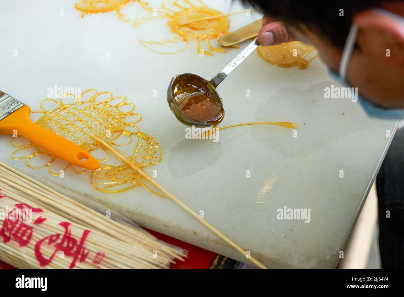 A craftsman is making traditional Chinese snacks, painting sugar ...