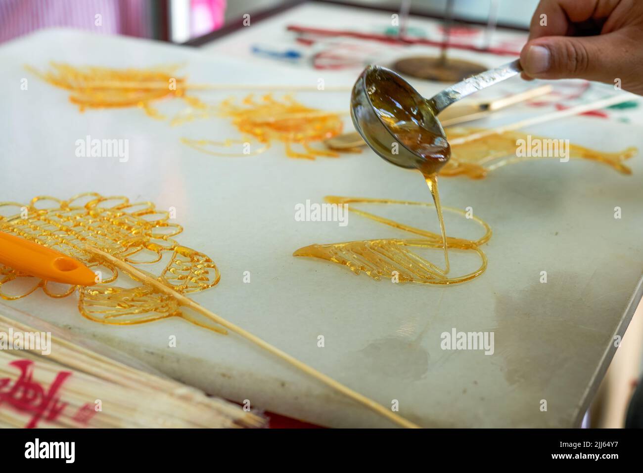 A craftsman is making traditional Chinese snacks, painting sugar ...