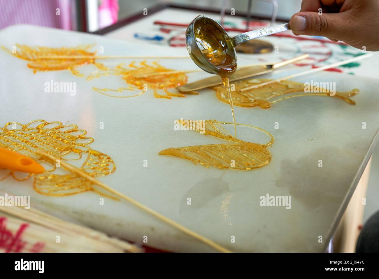 A craftsman is making traditional Chinese snacks, painting sugar ...
