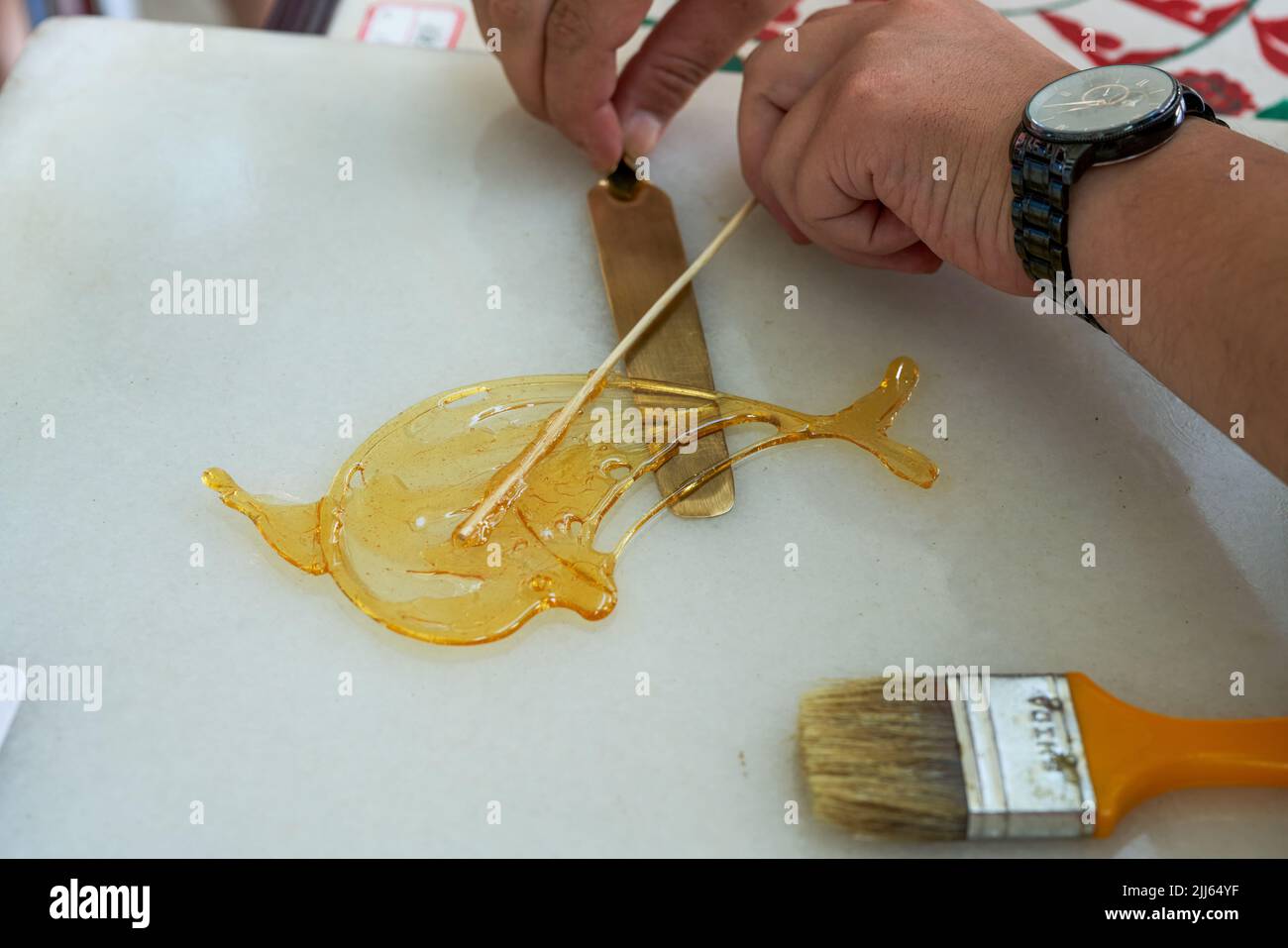 A craftsman is making traditional Chinese snacks, painting sugar ...