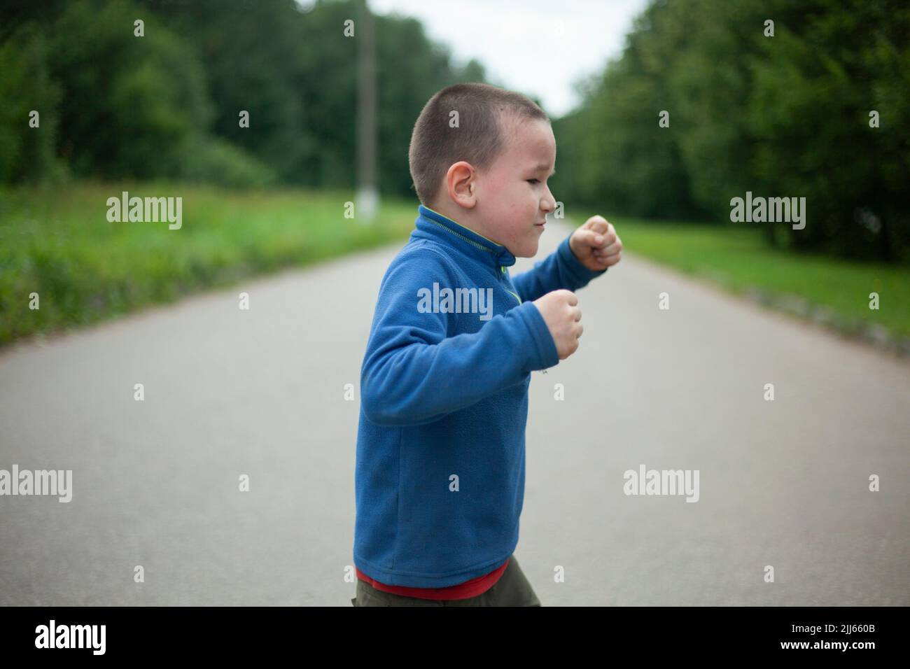 Child is angry. Boy threatens. Schoolboy swears in street. Negative ...