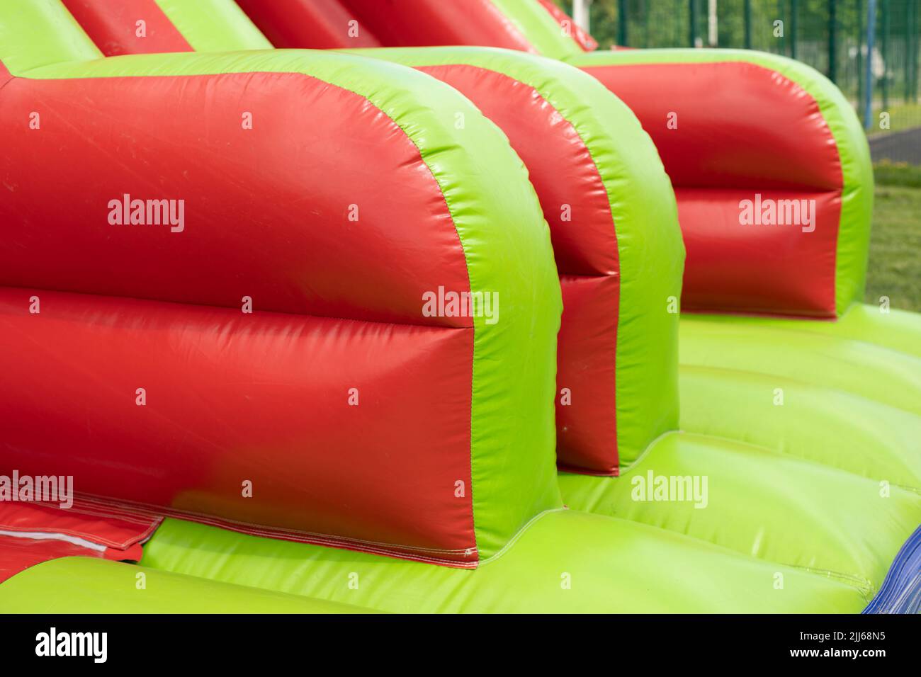 Inflatable slide of red color. Obstacle course in summer. Amusement ...