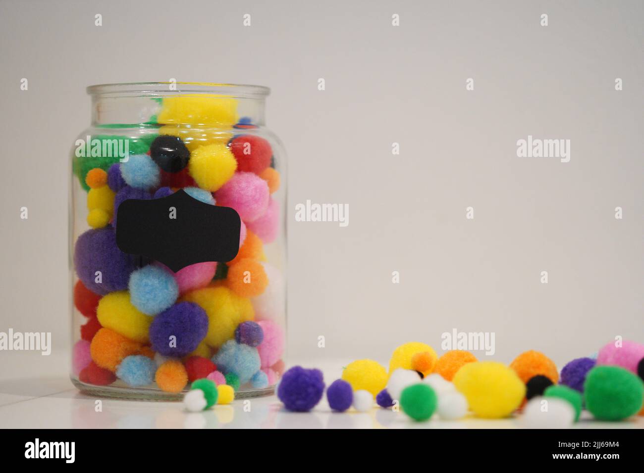 Colourful pom pom on a jar with background space for text. Background ...