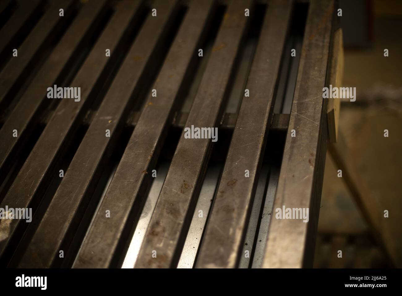 Steel profile lies in row. Metal production. Item in garage. Black ...