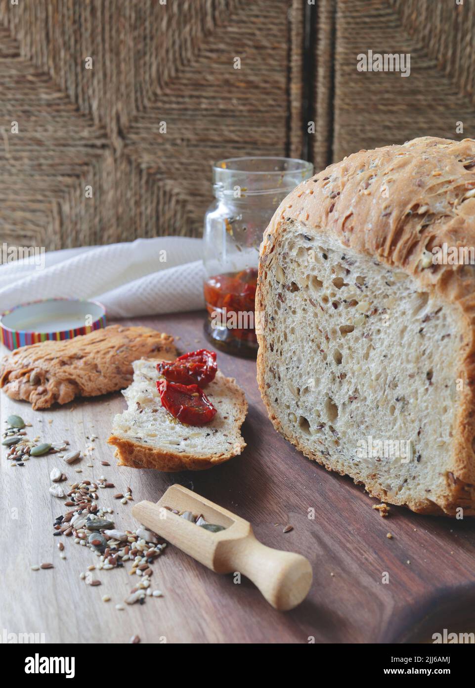 loaf of homemade whole grain bread and a cut off slice of bread ...