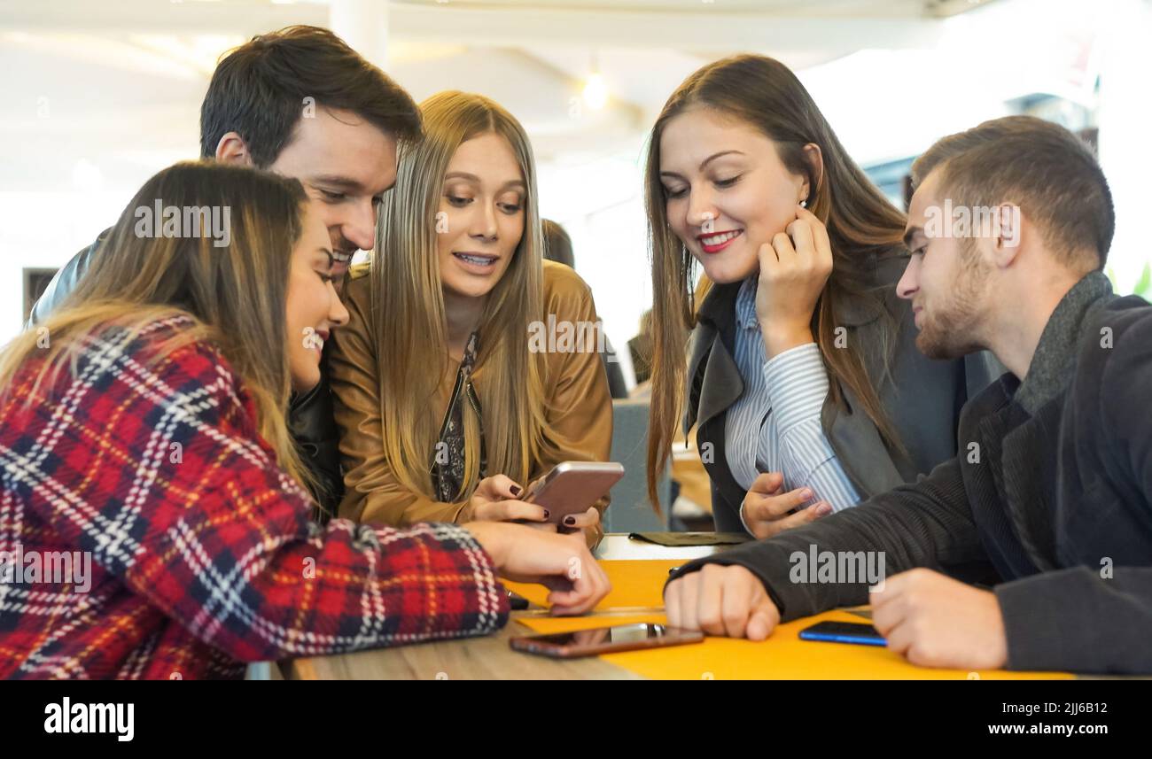 Group of friends hanging out with each other sitting in a bar using ...