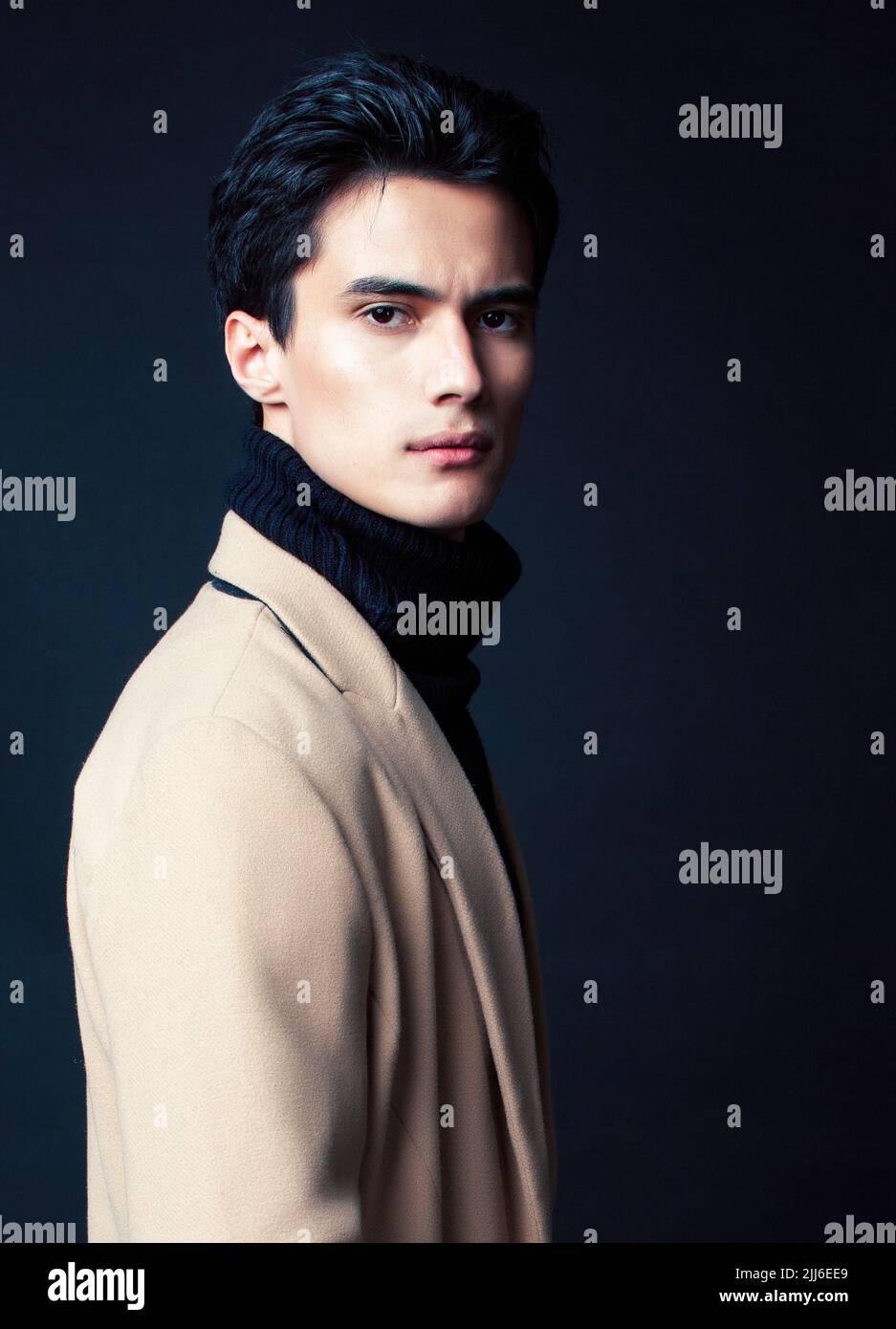 handsome asian fashion looking man posing in studio on black background ...