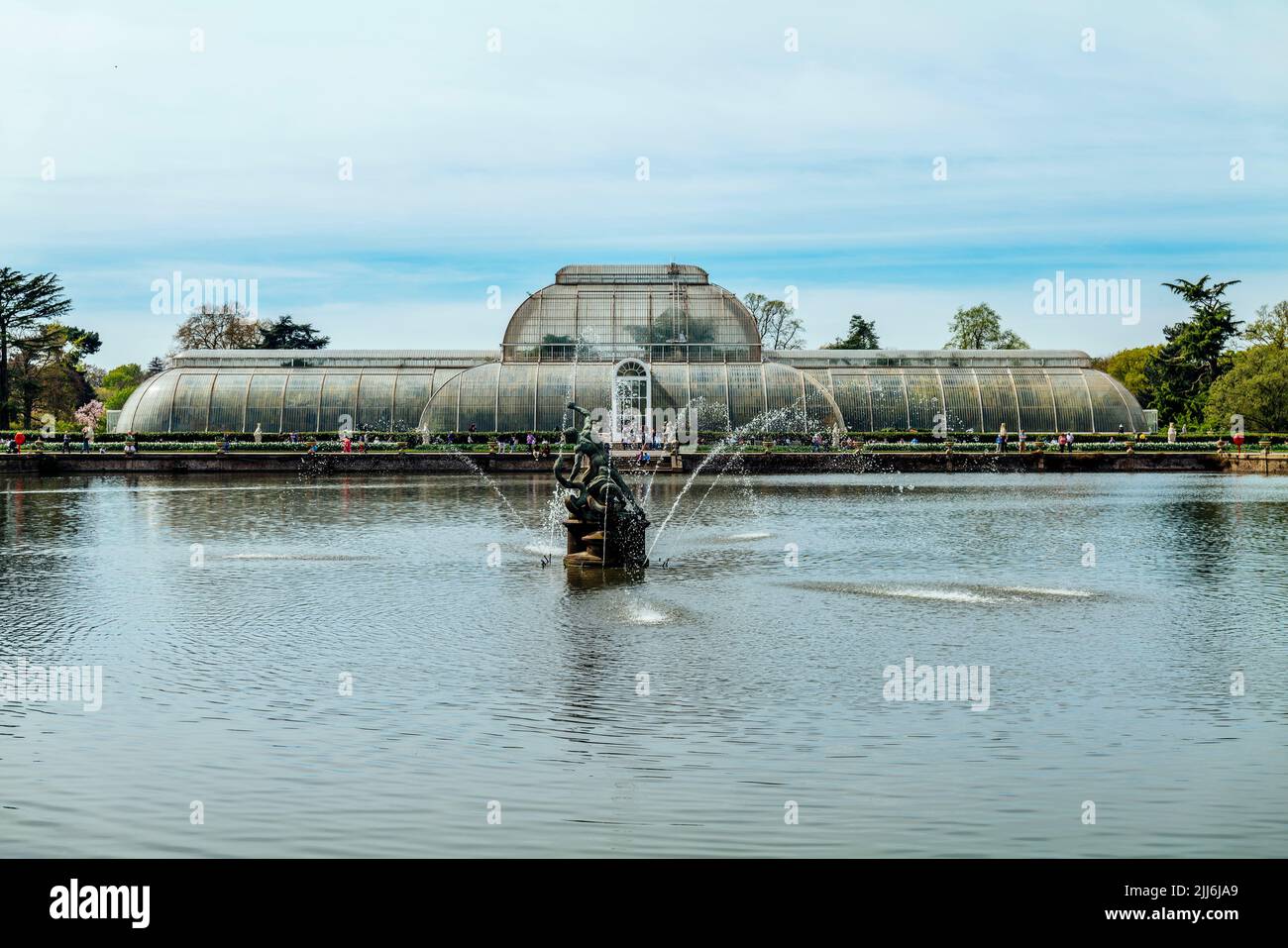 A view on fountain and the Palm House, an orangery inside Royal Botanic ...