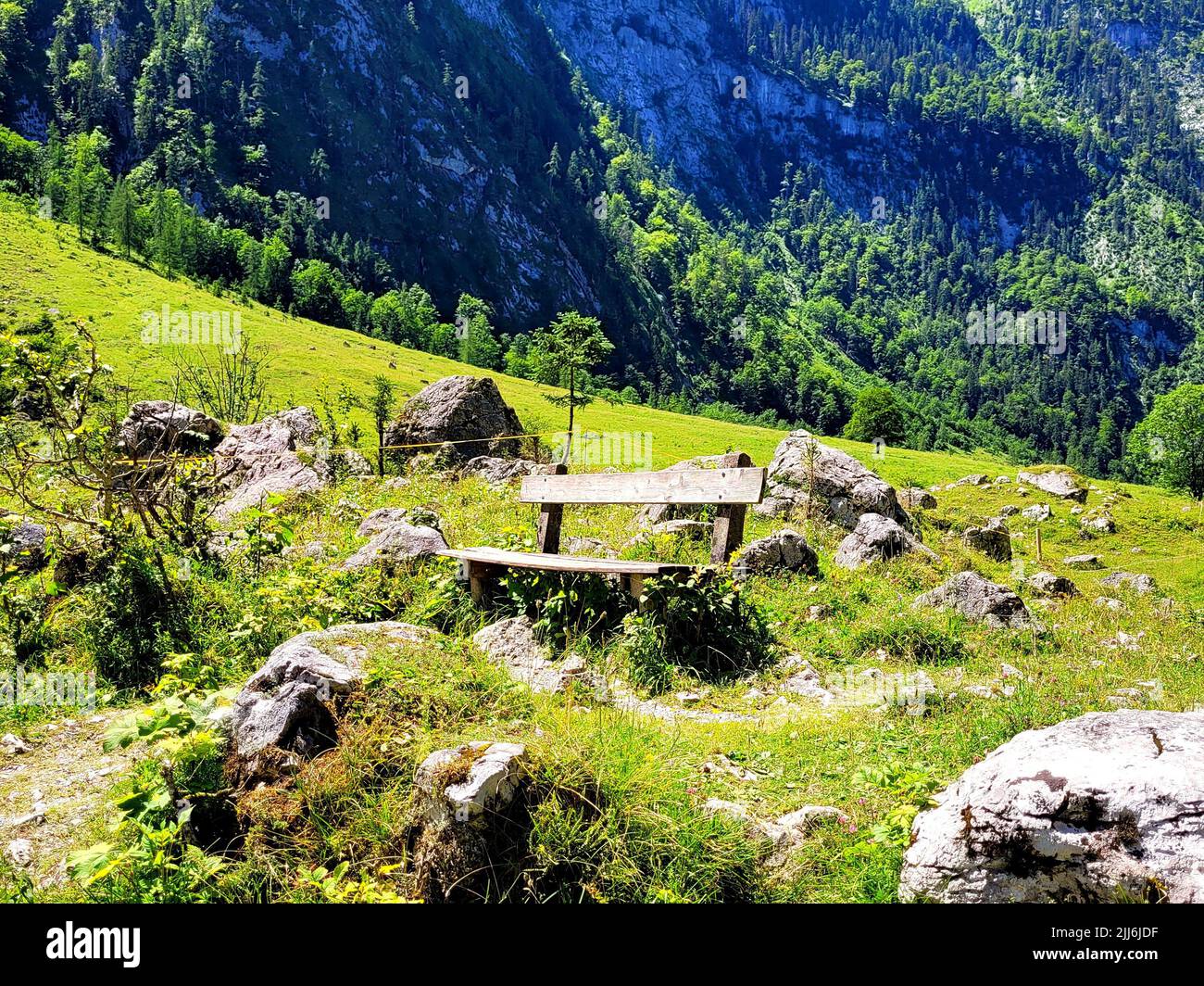 A wooden bench on a green rocky valley Stock Photo - Alamy