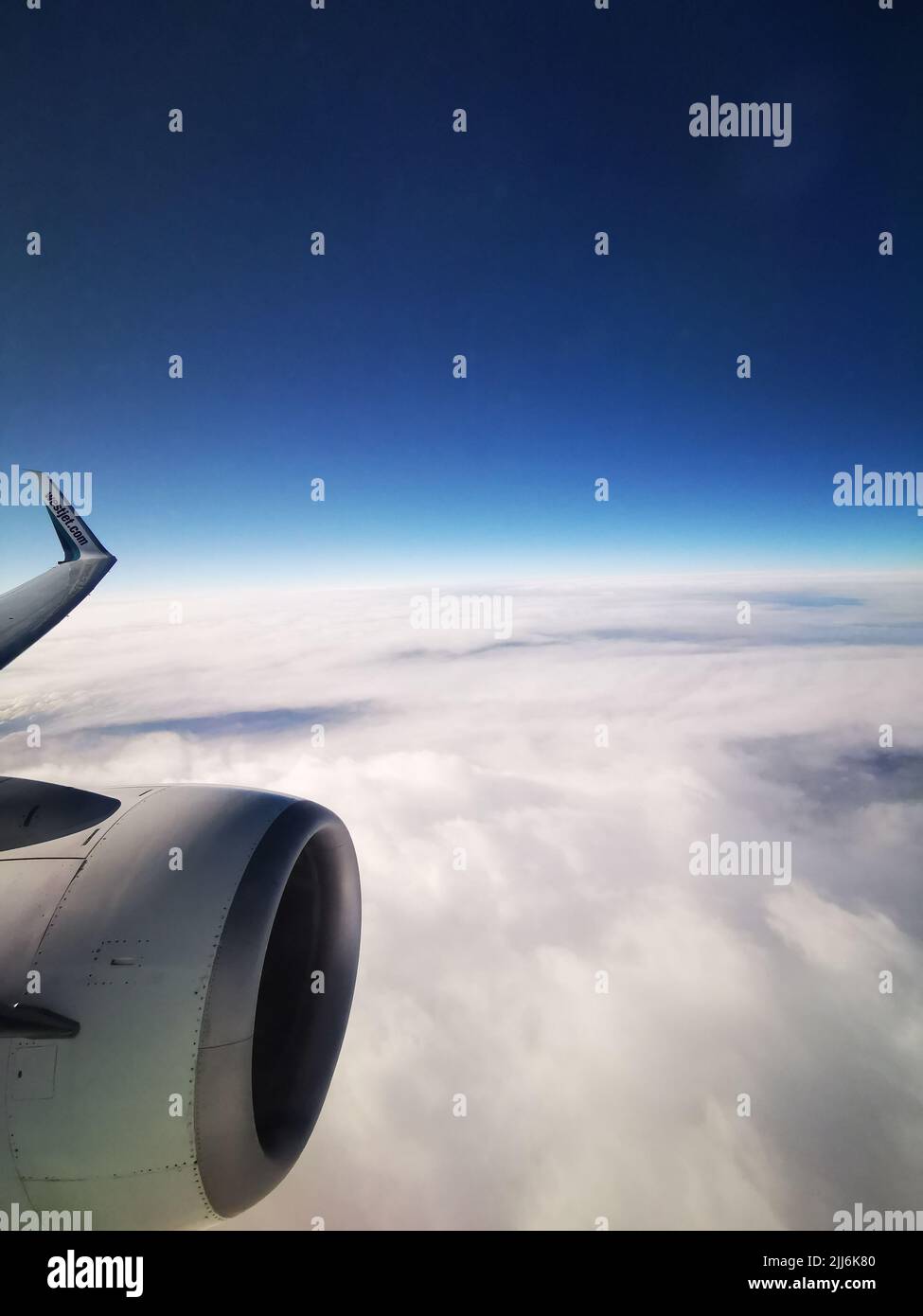 A vertical shot of the plane wing, sky and clouds, captured during the ...