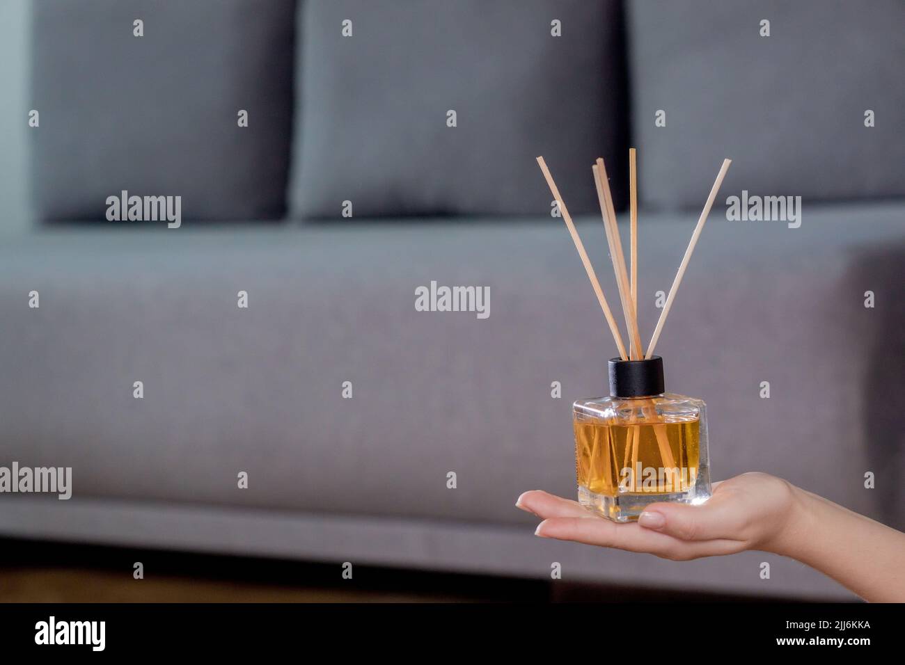 Aromatic cane air freshener woman holding in hand on room background ...