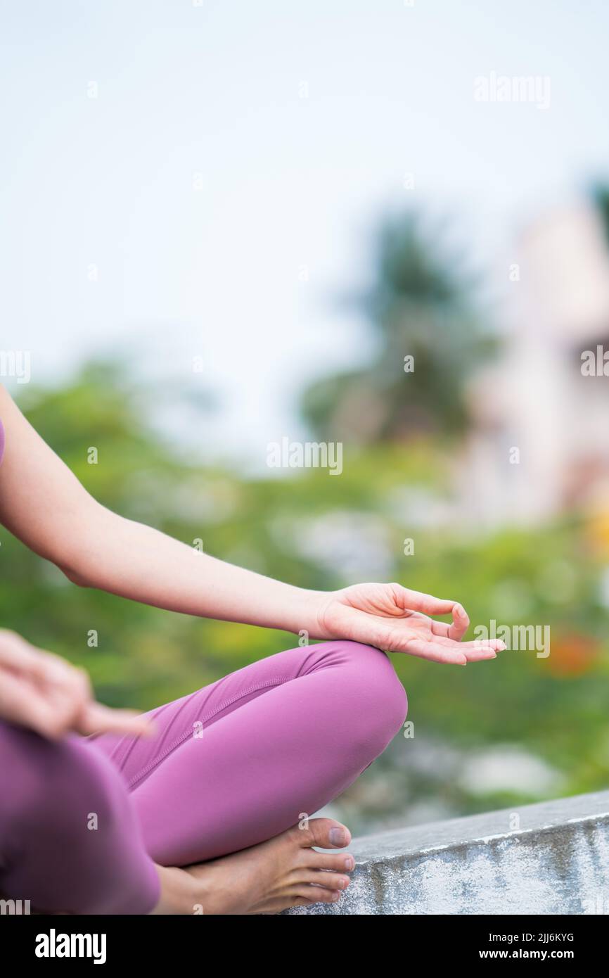 The hands on knees of Caucasian woman yogini meditating on a natural ...