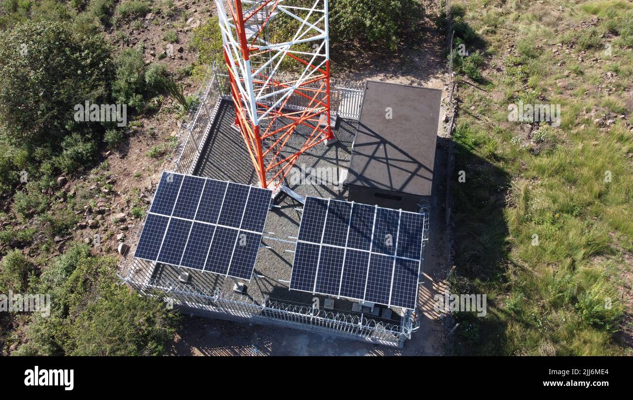 An aerial view of solar panels under a telecommunication tower Stock Photo - Alamy