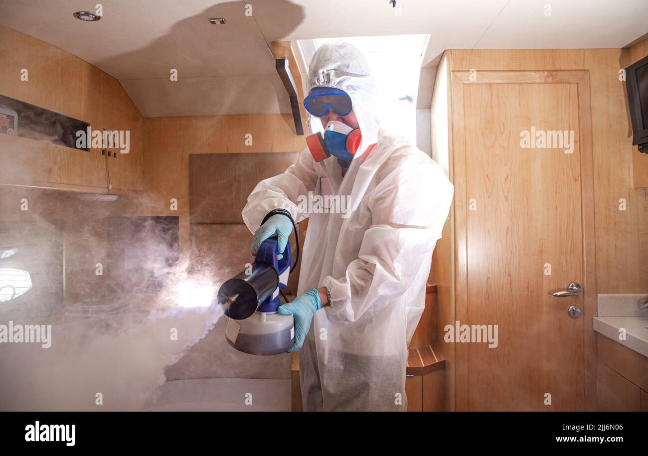 disinfection of the room against viruses. Man in quarantine clothes ...