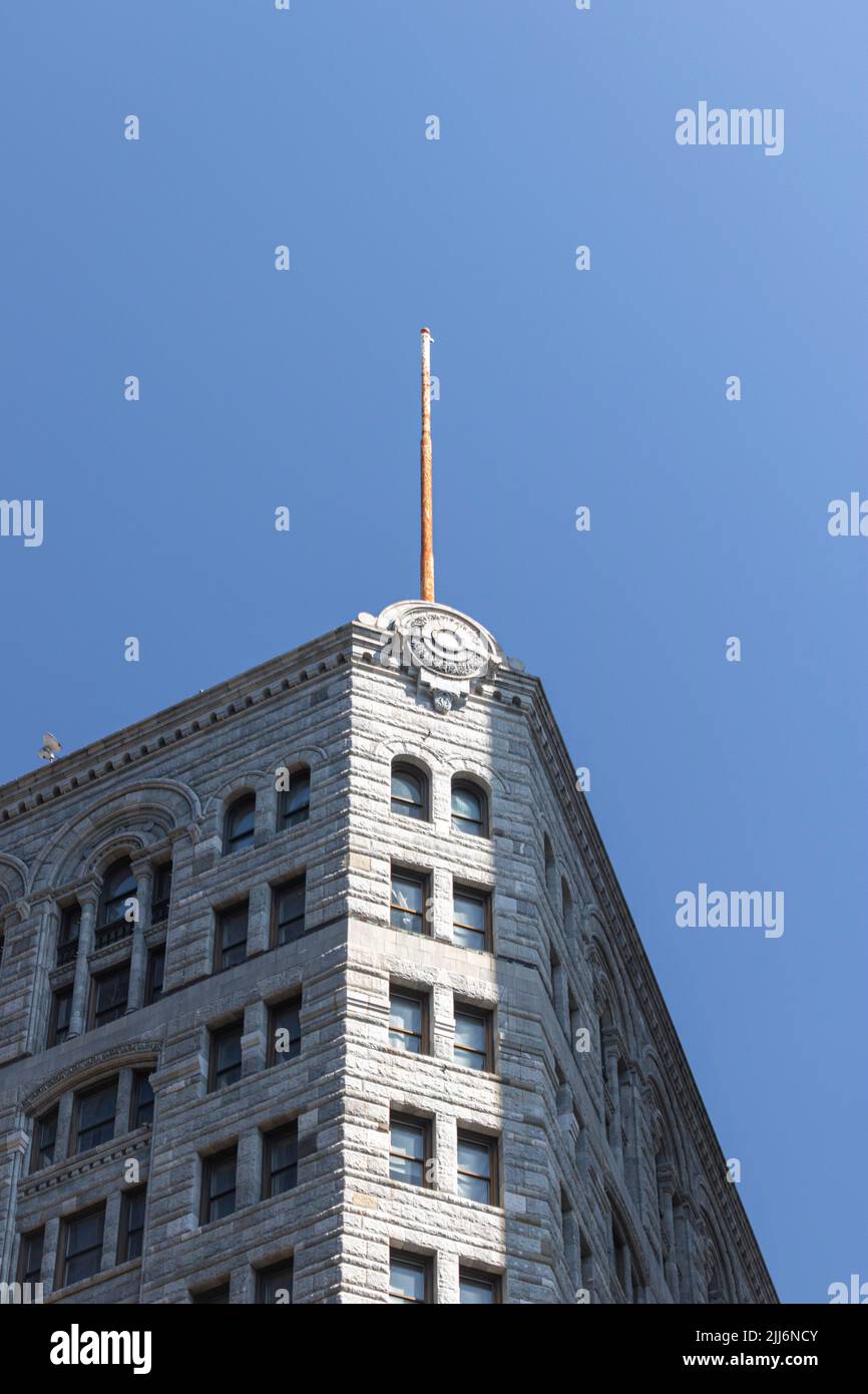 A vertical shot of an old classic building with an empty flag pole on ...