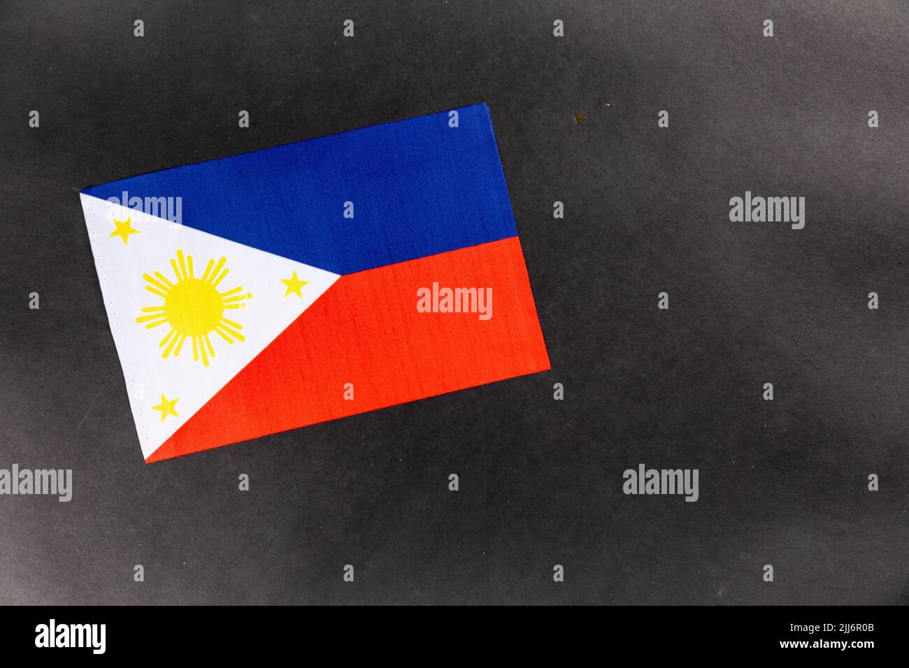 A close-up shot of the flag of the Philippines on a dark background ...