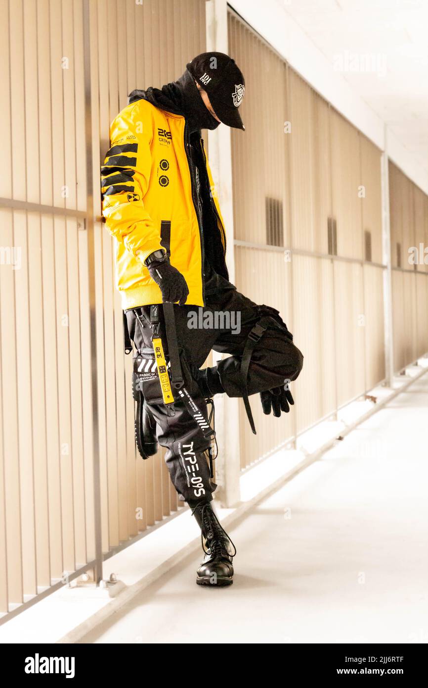 A vertical shot of a stylish man wearing a bright yellow jacket and ...