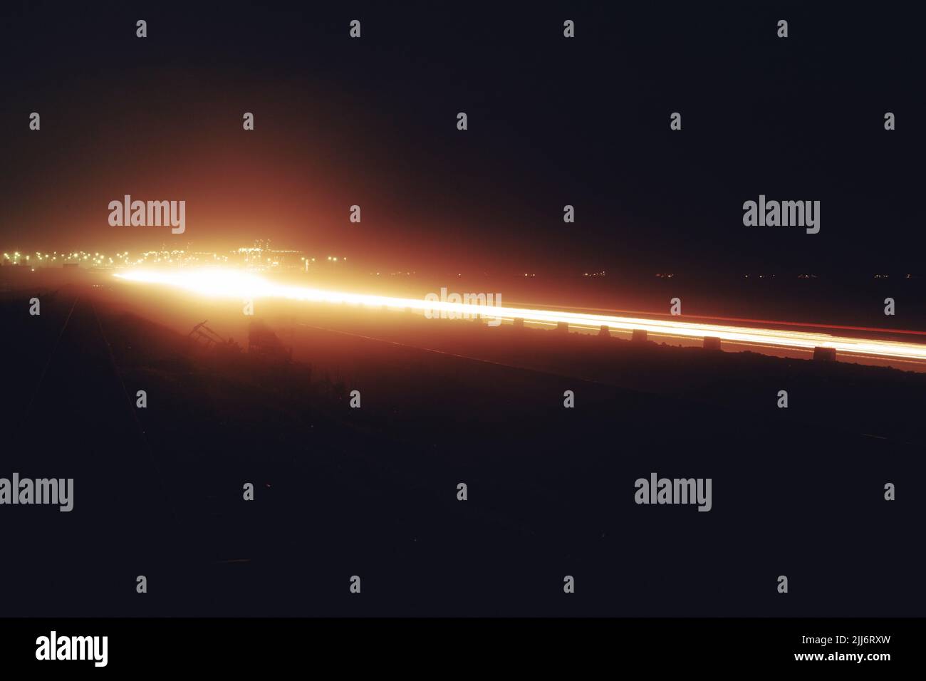 A high-speed shot of cars on a road during sunset with long exposure ...