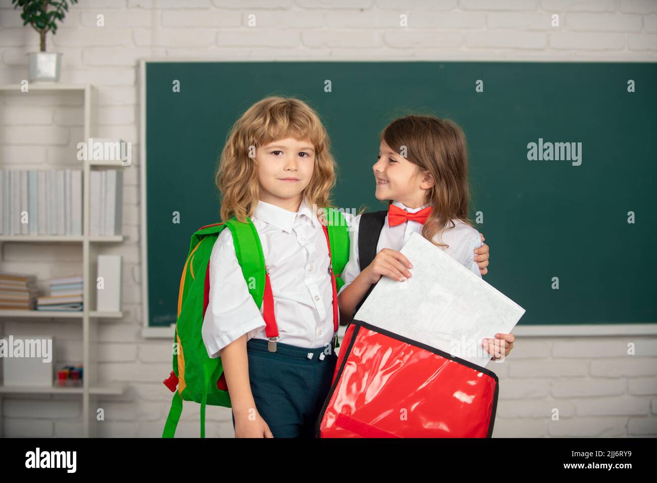 Friendly classmates in school uniform at lesson. Boy girl school ...