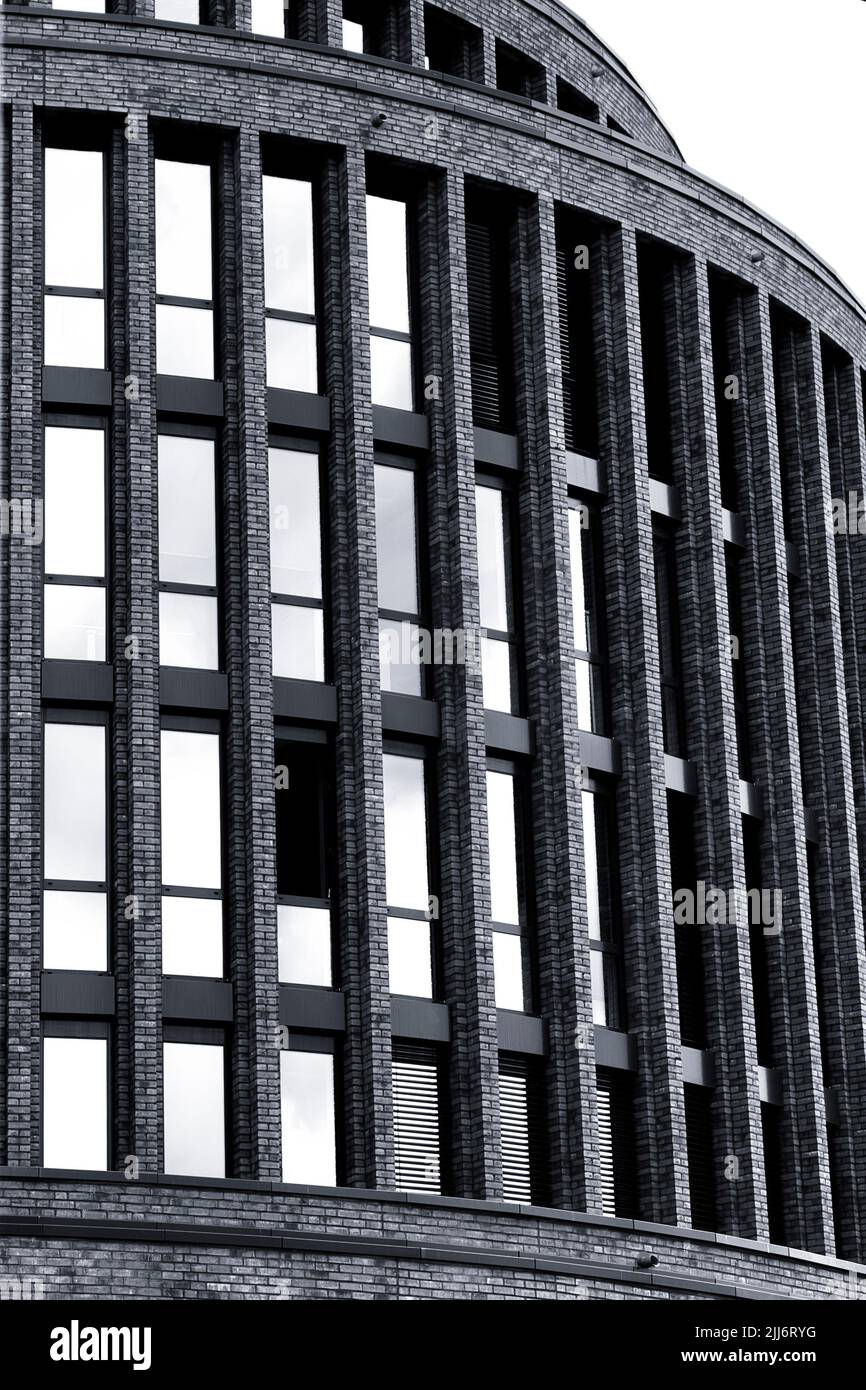 A vertical greyscale of a building with long brick texture columns on ...
