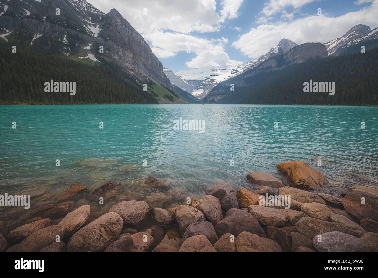 Scenic, rocky shoreline of Lake Louise and Victoria Glacier landscape ...