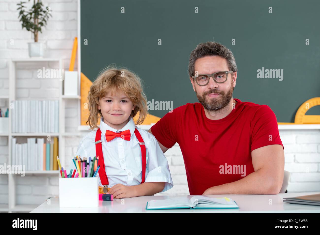 First day at school. Cute little boy from elementary school and tutor ...