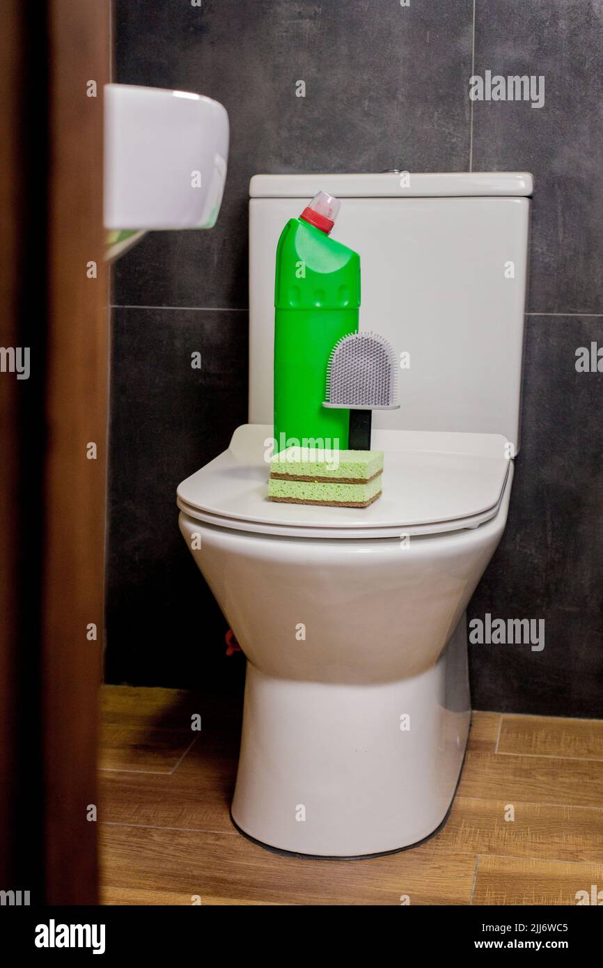Toilet cleaner, a toilet brush and a washcloth on the toilet. Toilet ...