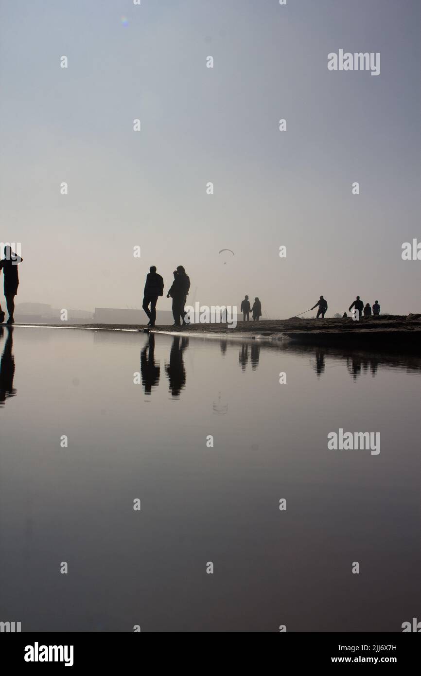 The people reflected in sheet of water at sea Stock Photo - Alamy